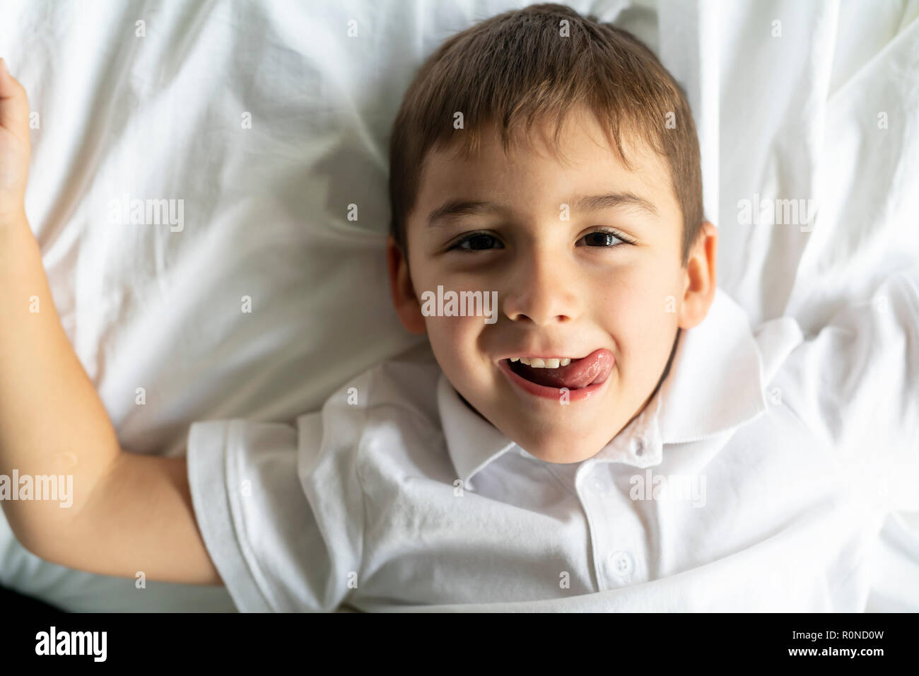 A Little boy lay on the bed with white blanket Stock Photo - Alamy