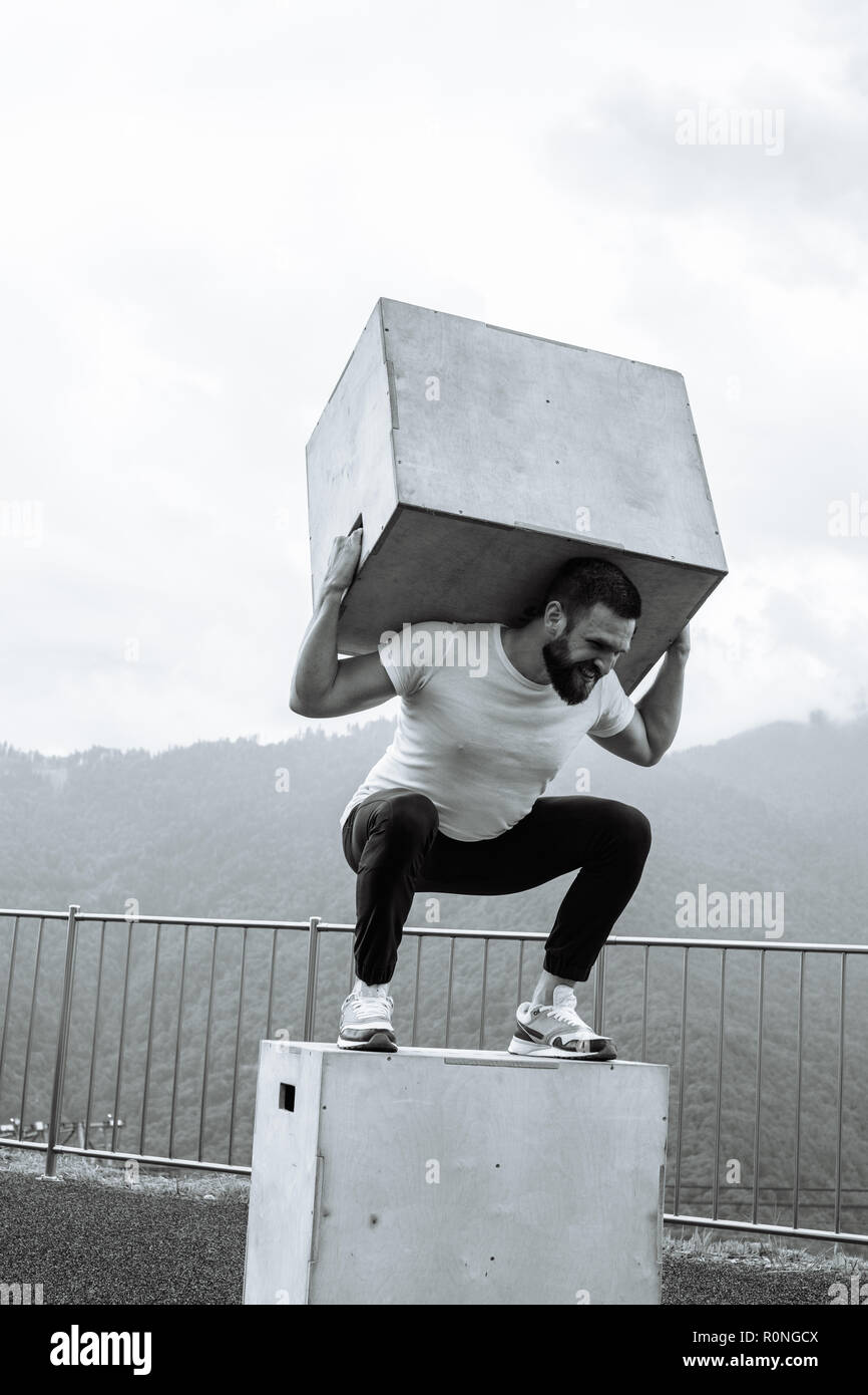 Crossfit man doing squats with weight over mountain nature background ...