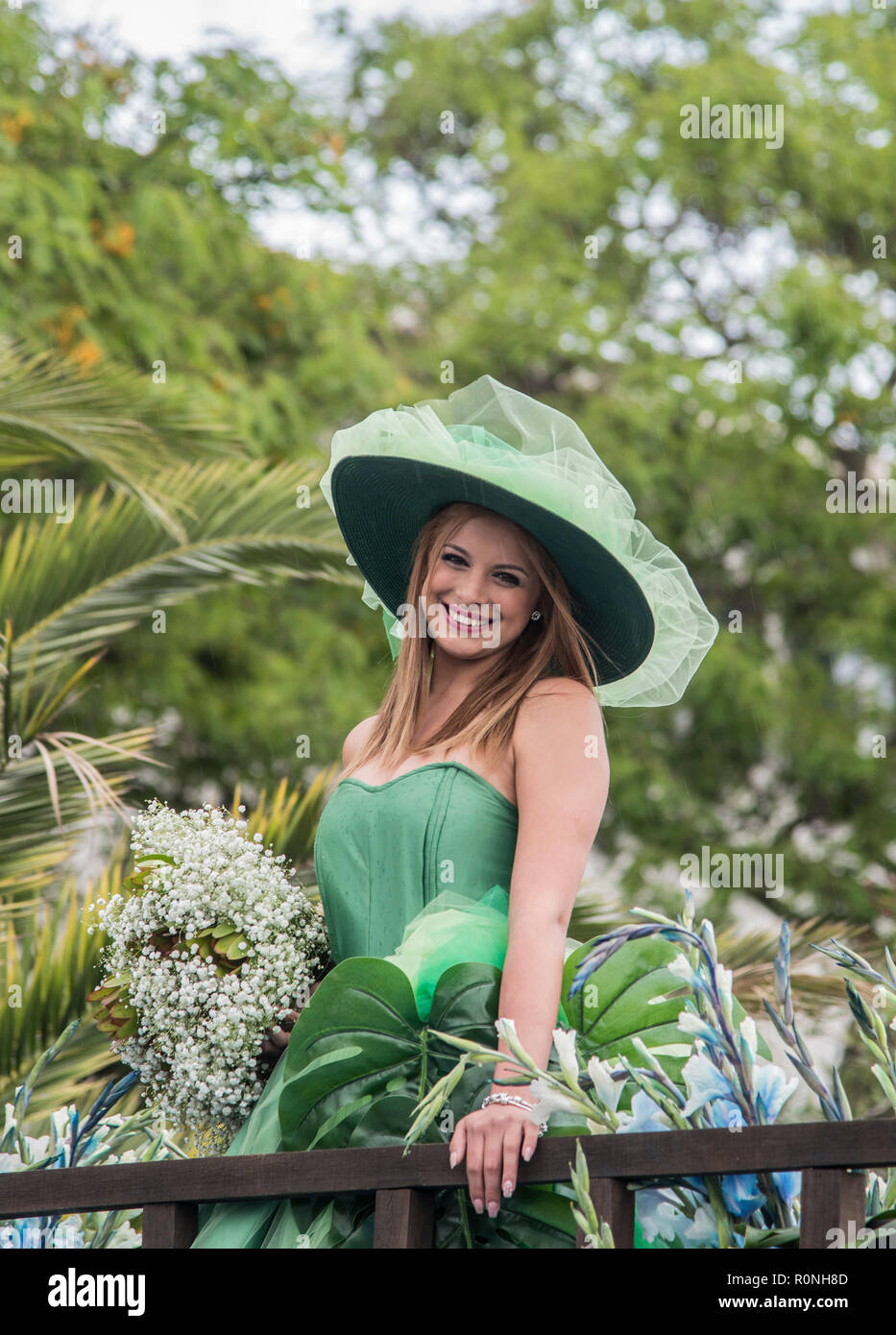 Attractive young lady wearing colourful flowery hat during a Madeira ...