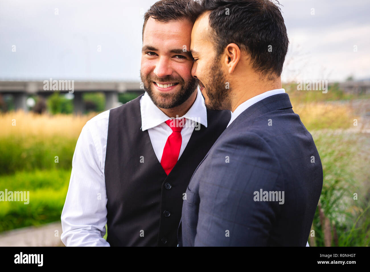 Handsome gay male couple in the park on their wedding day Stock Photo ...