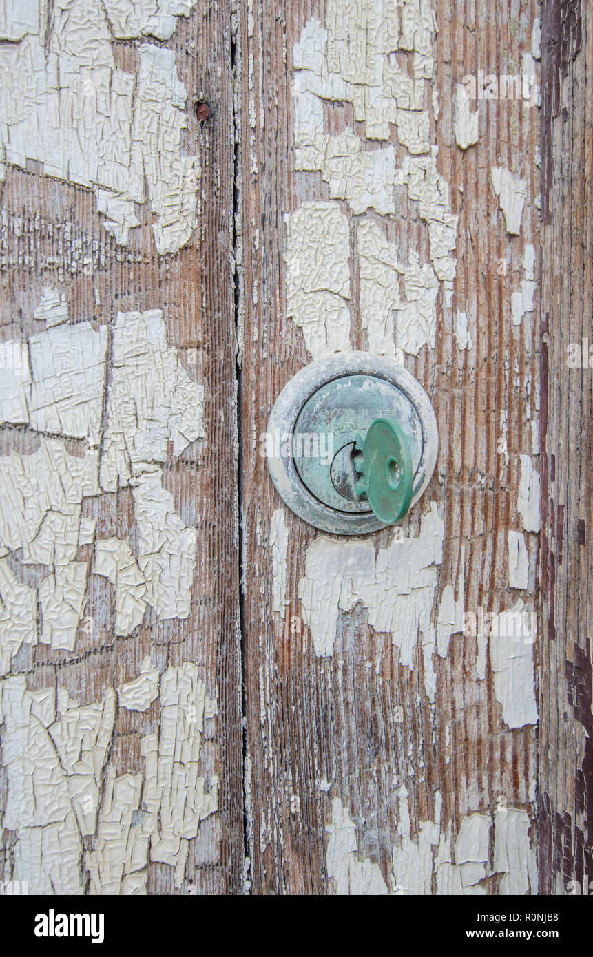 Corroded old lock and key in a wooden door with flaking paint Stock ...