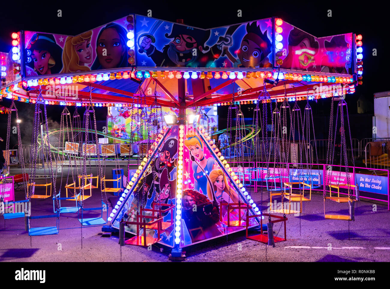 A deserted neon-lit carousel in a fun fair in Machynlleth, Wales, UK ...