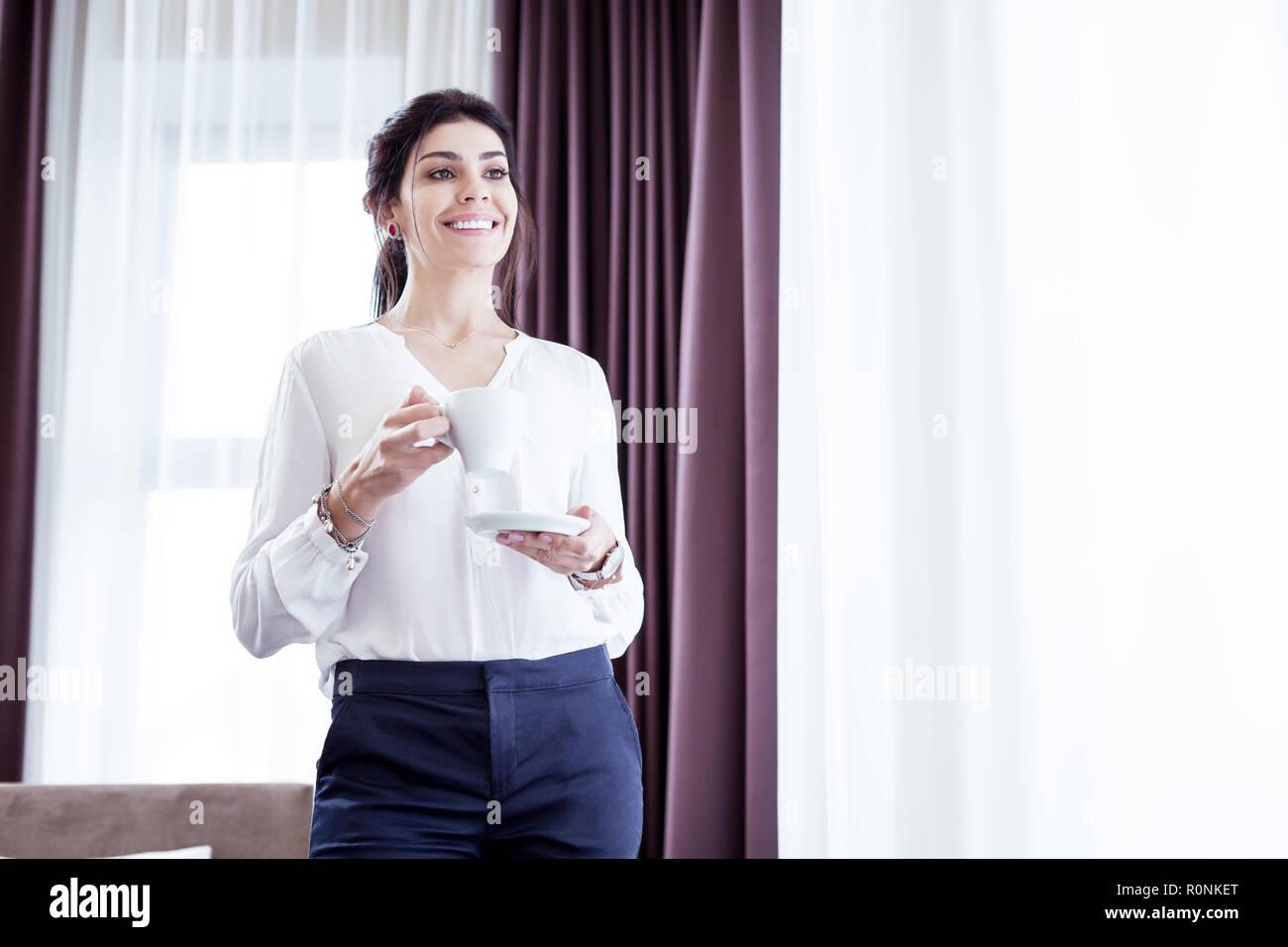 Positive attractive businesswoman drinking her favourite coffee Stock ...