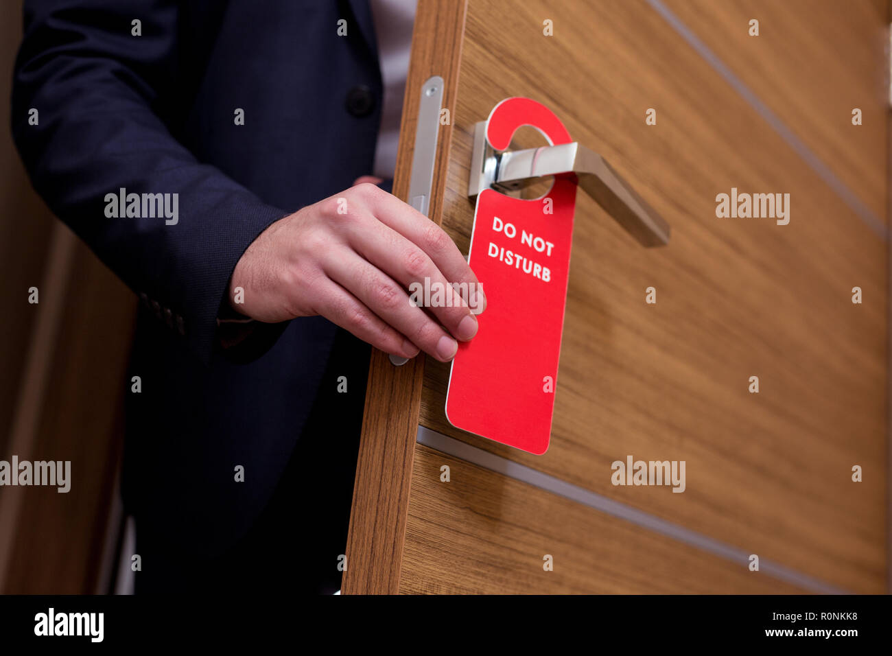 Nice handsome man putting do not disturb sign Stock Photo - Alamy