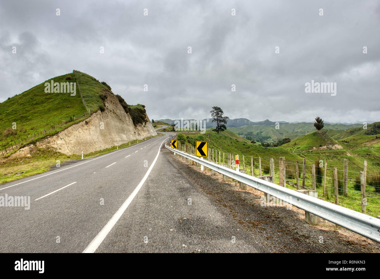 An asphalt road running through green countryside on an overcast day ...