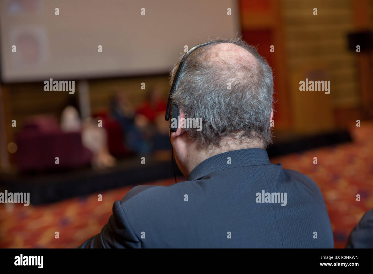 Unrecognizable business people using headphones for translation during ...