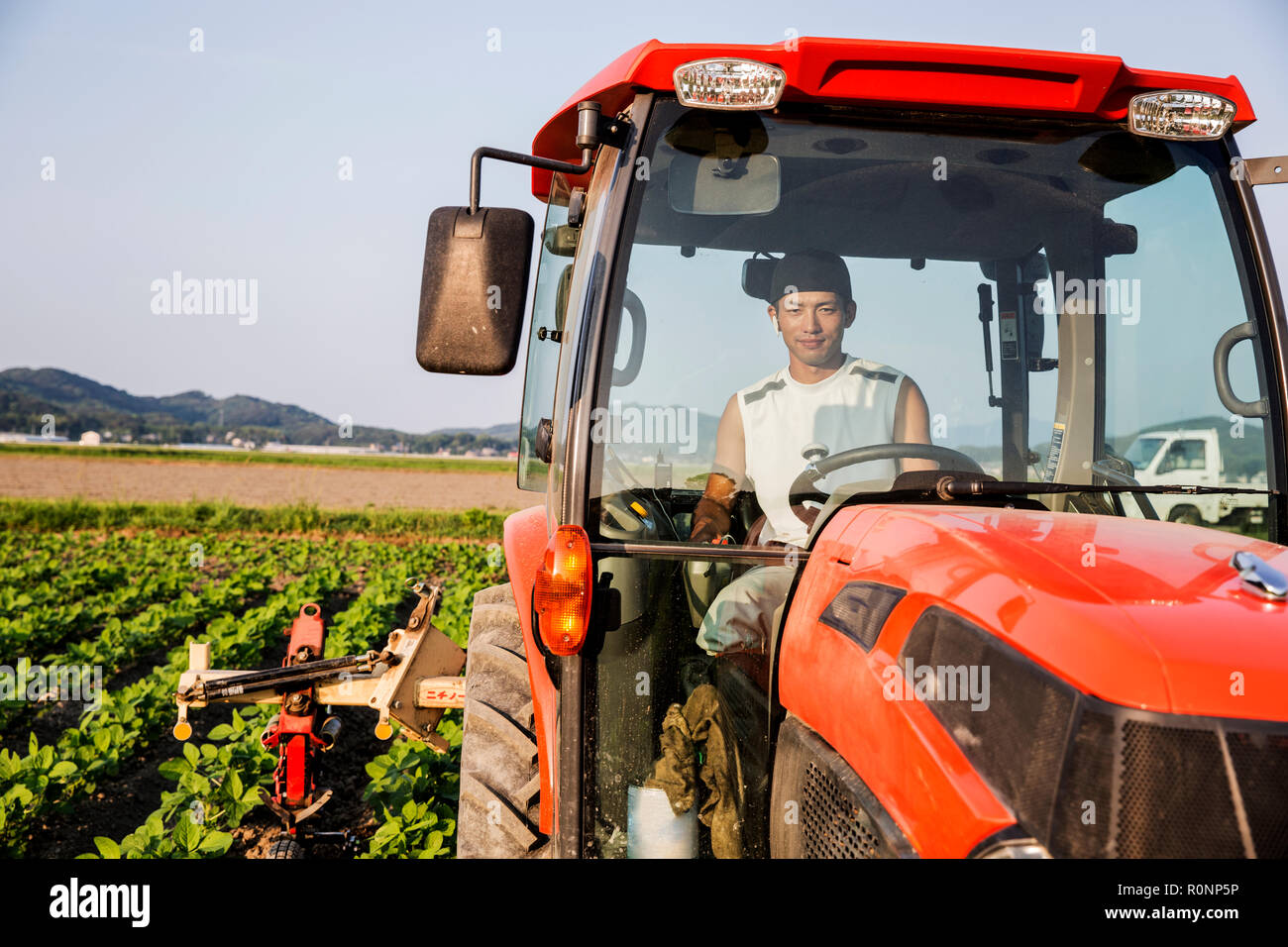Portrait of Japanese farmer driving red tractor Stock Photo - Alamy
