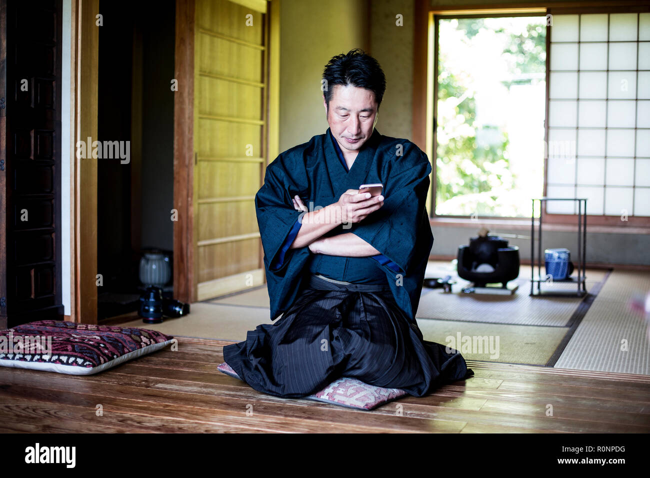 Japanese man wearing kimono sitting on floor in traditional Japanese ...