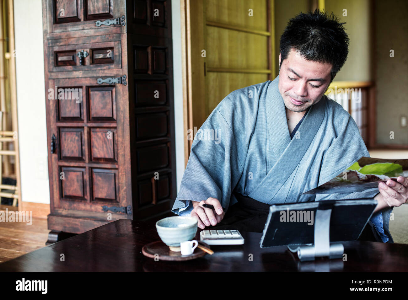 Japanese man wearing kimono sitting on floor in traditional Japanese ...