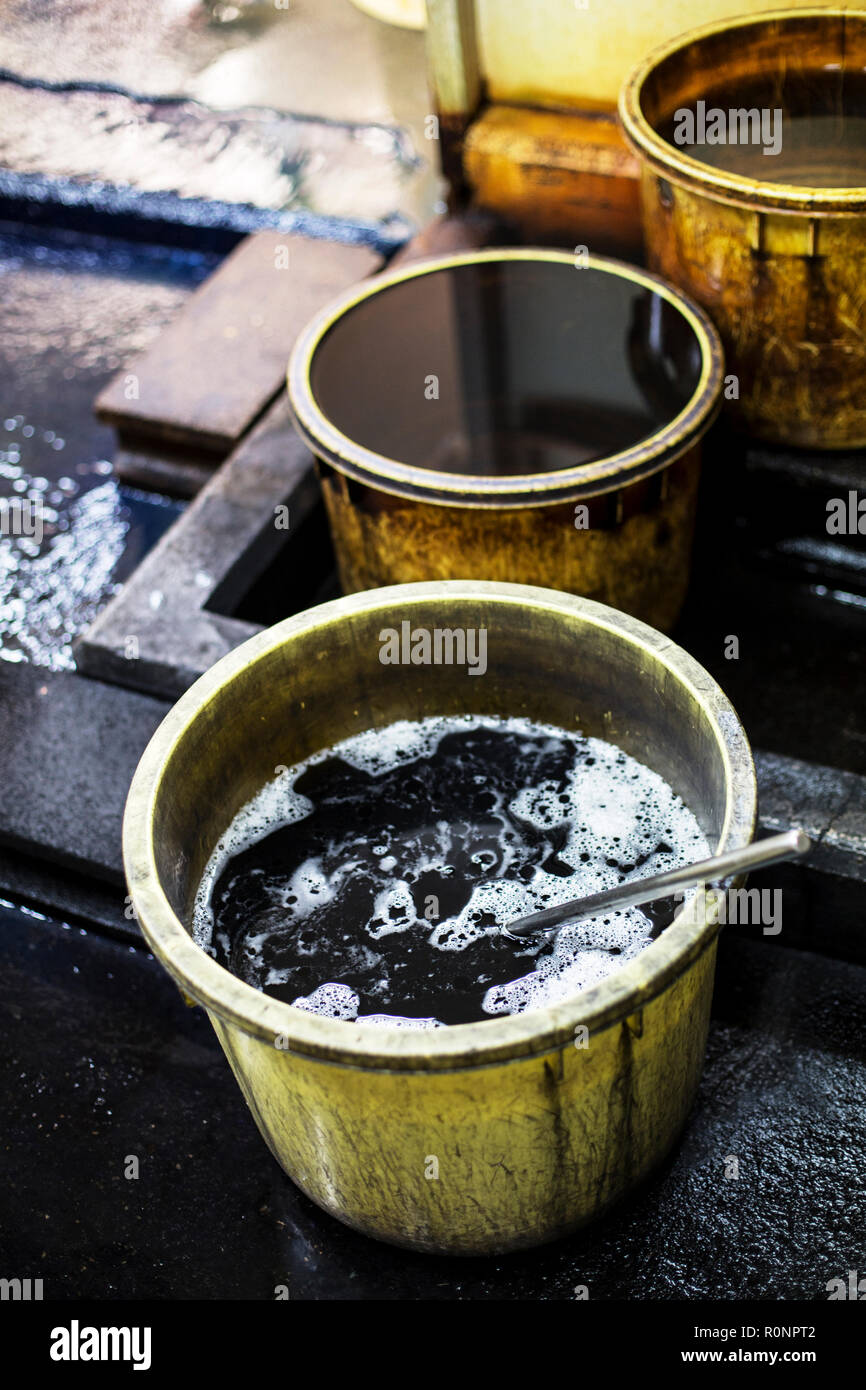 High angle close up of bucket with blue dye in a textile plant dye ...