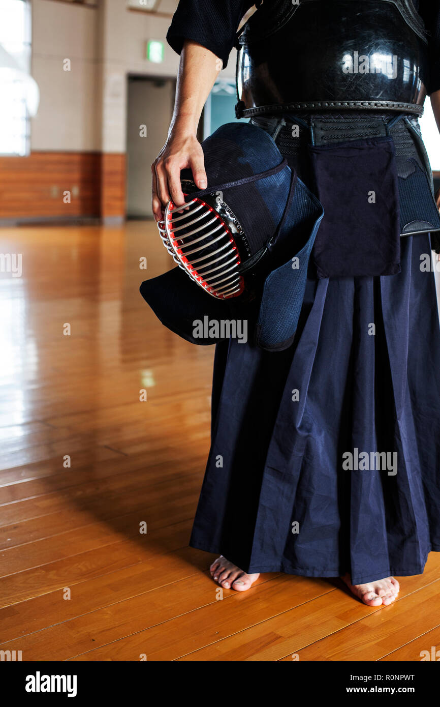Male Japanese Kendo fighter standing in a gym, holding Kendo mask Stock ...