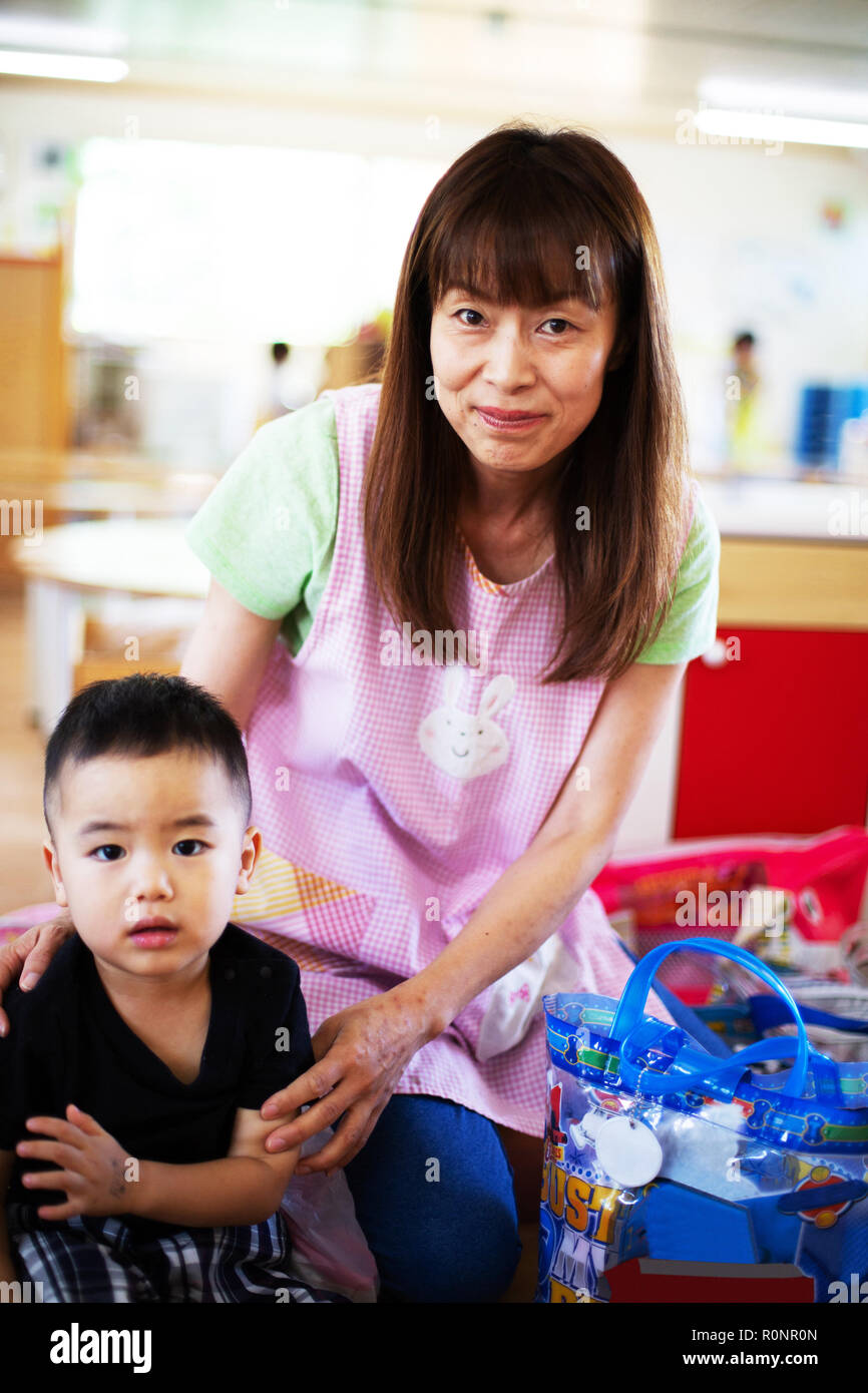 Female teacher and boy in a Japanese preschool, smiling at camera Stock ...