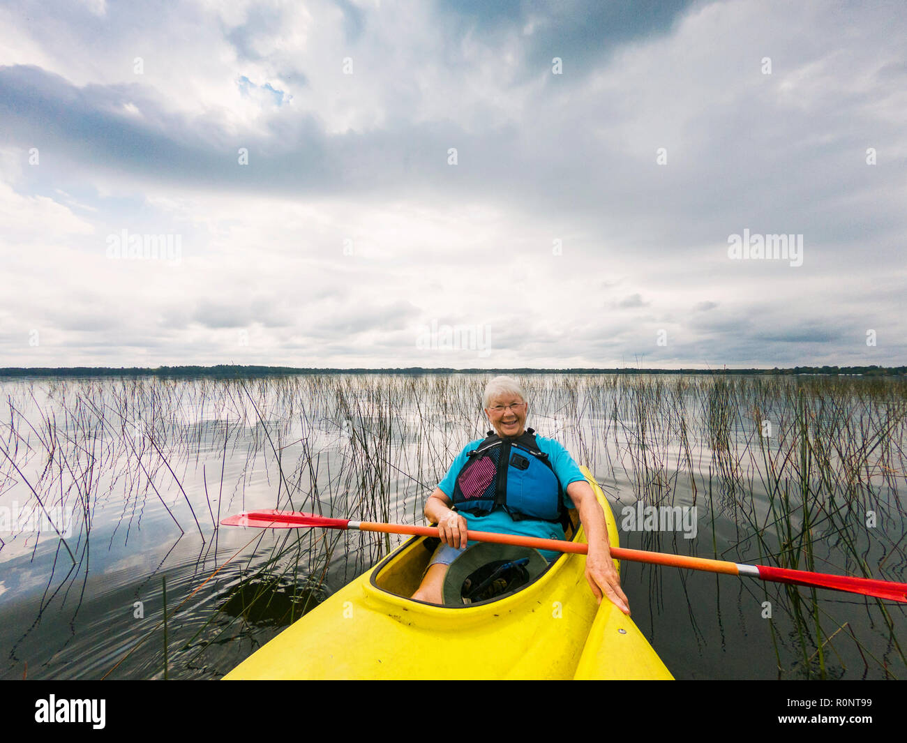 Smiling senior woman kayaking on a lake, United States Stock Photo - Alamy