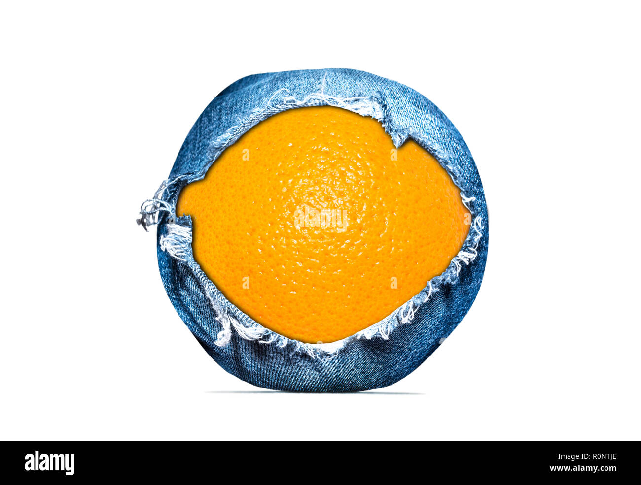 Creative photo of an orange close-up in a denim shell with a hole in a ...