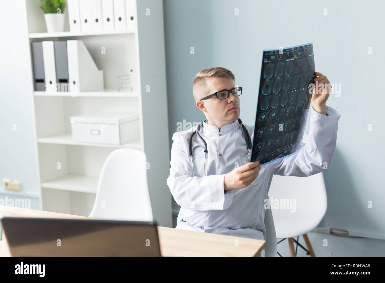 Medicine, healthcare and people concept - doctor examines an x-ray ...