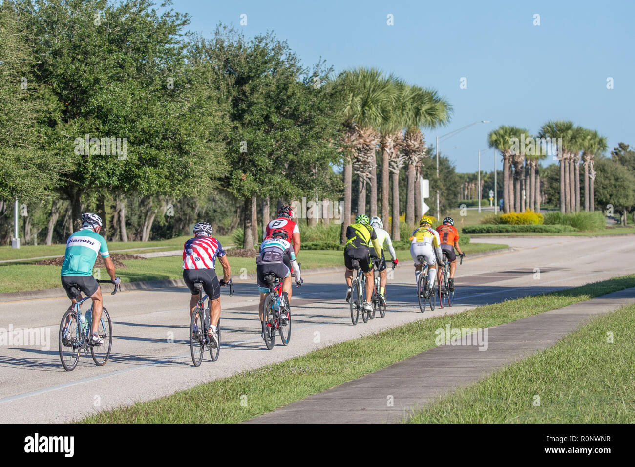 Group of colorful bicycle riders in a row on a street in Southwest ...