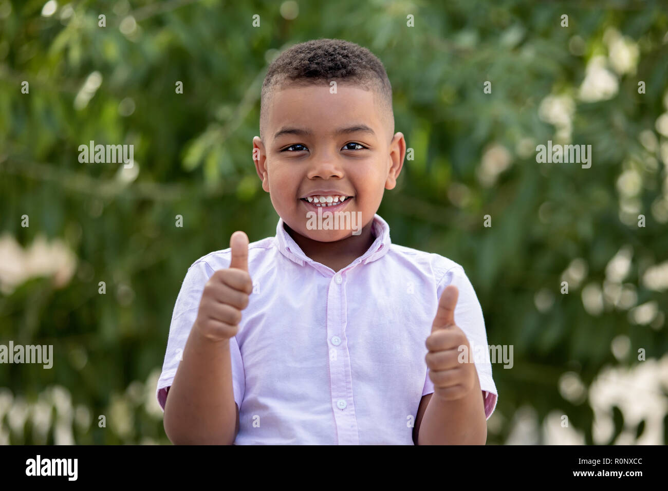 Latin child saying Ok in a garden Stock Photo - Alamy