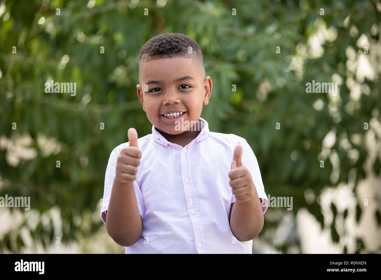 Latin child saying Ok in a garden Stock Photo - Alamy