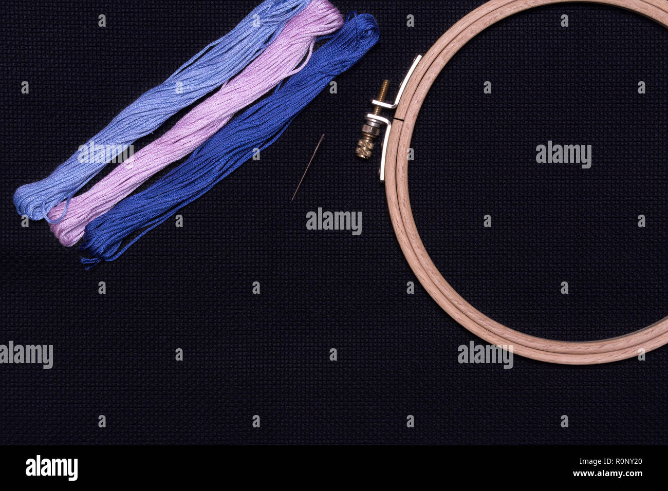 Tools for cross stitch. Threads, a hoop for embroidery and needle on a ...