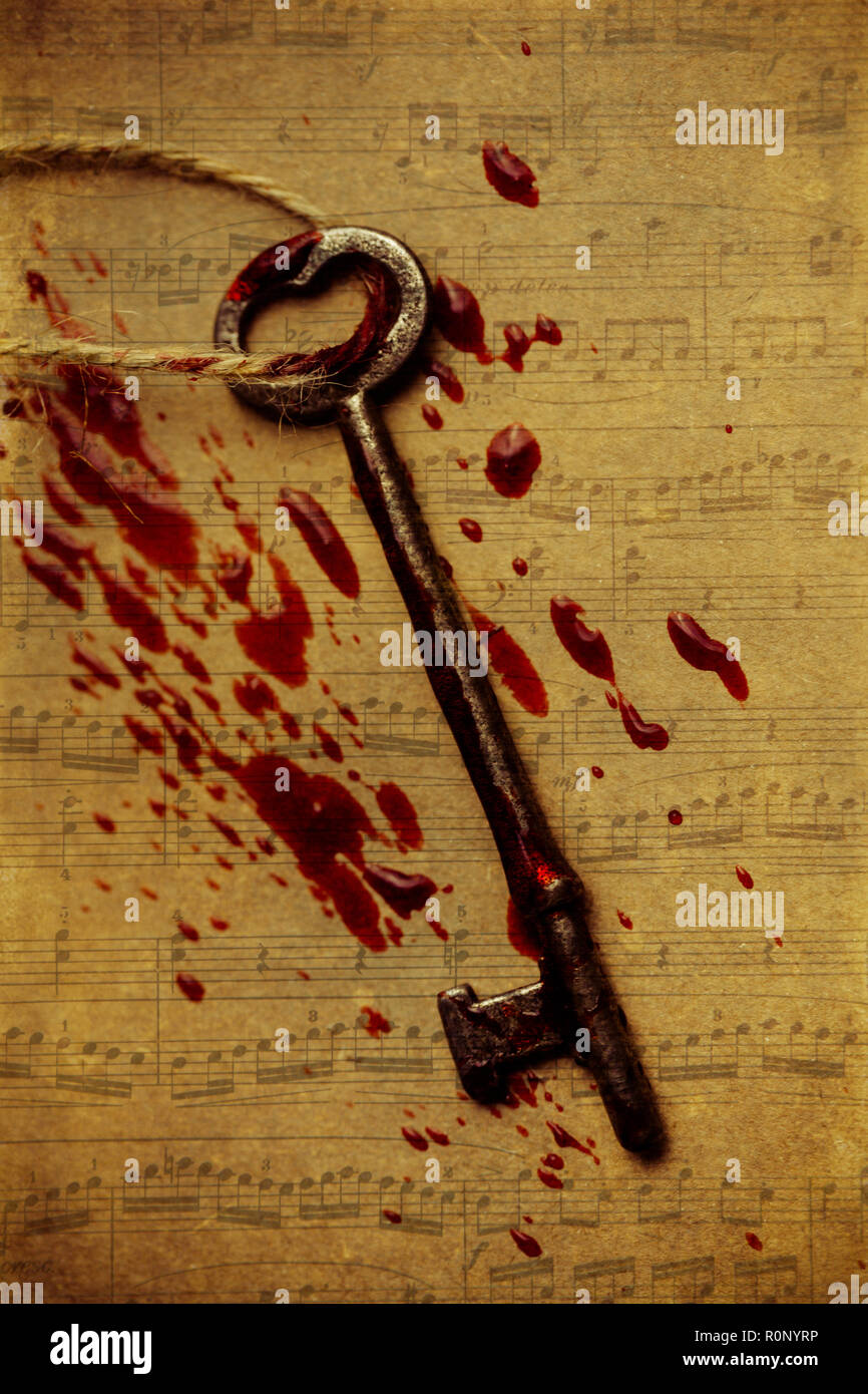 A vintage skeleton key, covered with blood sits on a sheet music ...