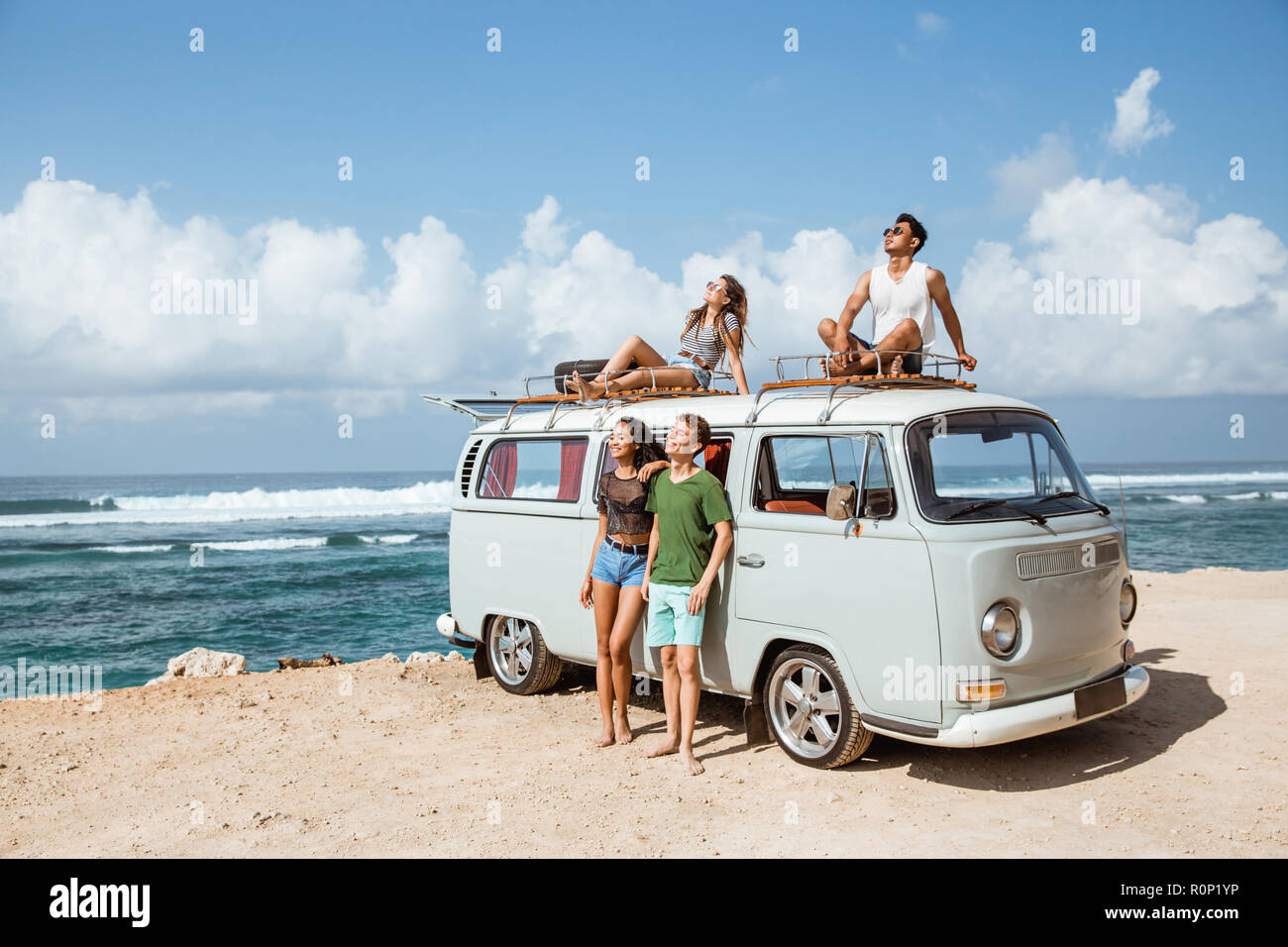 Hipster girl relaxing with friends on the retro van roof Stock Photo ...