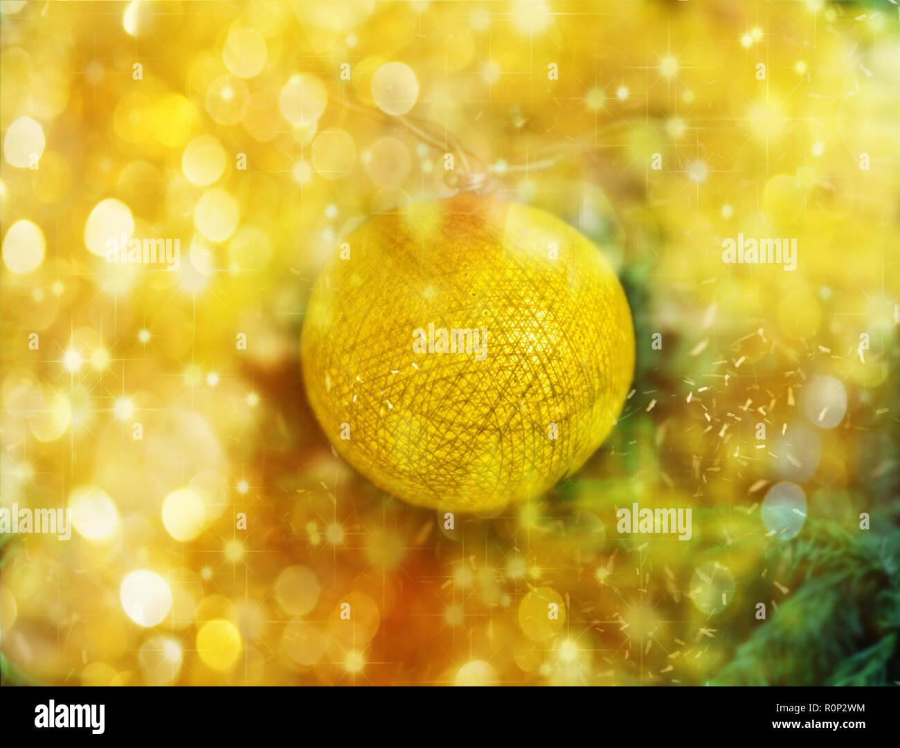 Yellow glowing ball of threads on Christmas tree in bright lights Stock ...