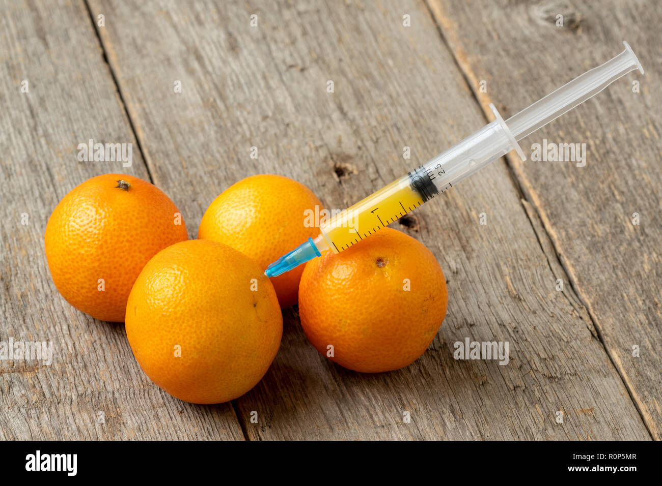 Syringe and mandarins. Concept for genetically modified food and ...
