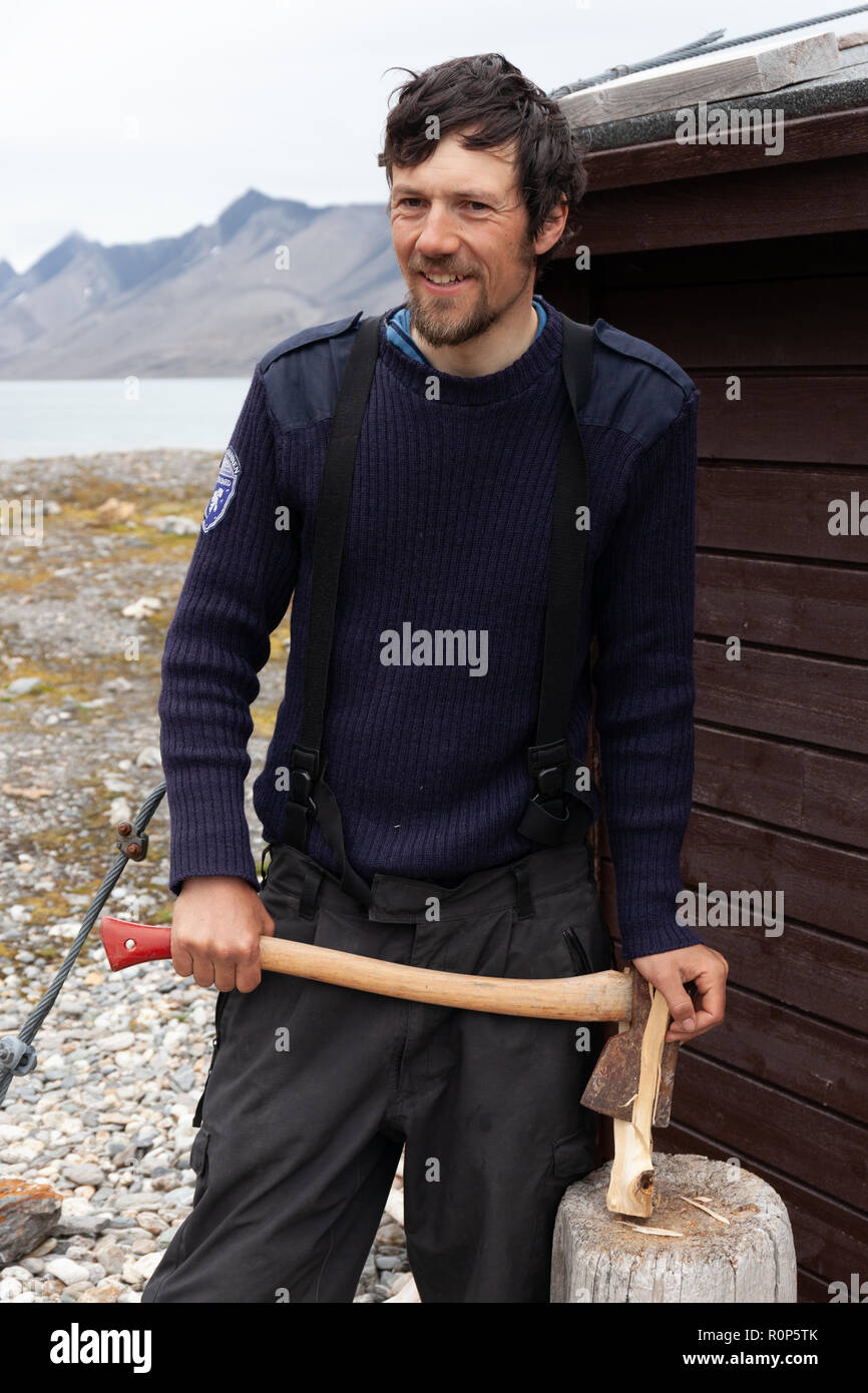 A police officer chops wood outside his isolated station as part of his ...