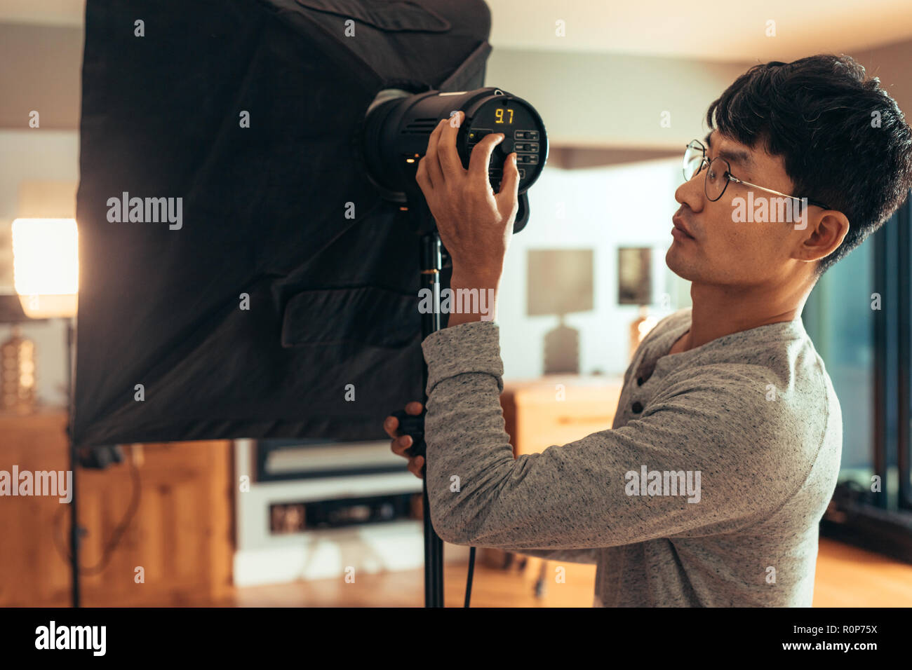 Photographer adjust softbox light intensity in studio. Man setting ...
