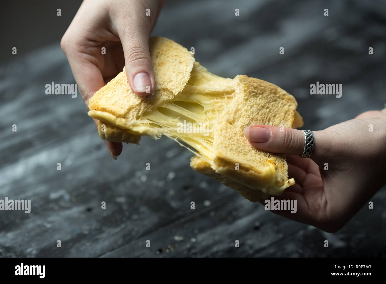 baked toast with stretched cheese in the hands of a woman Stock Photo ...