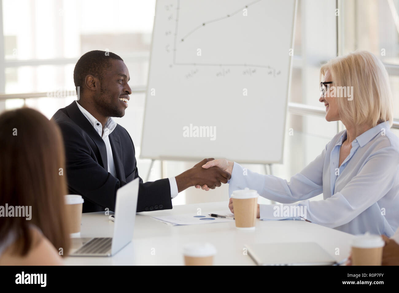 Diverse employees handshake getting acquainted at briefing Stock Photo ...