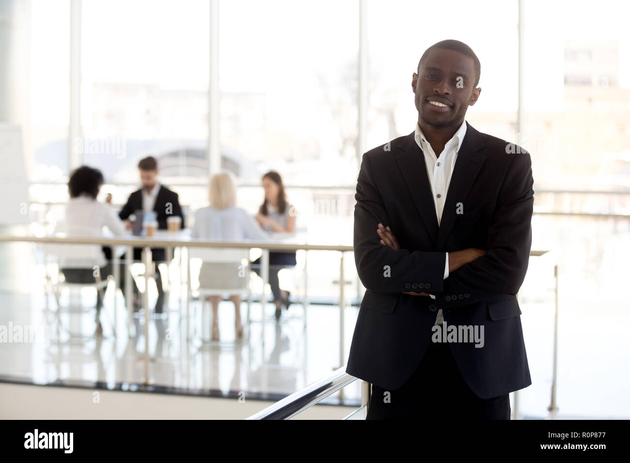 Portrait of smiling black businessman standing posing in office Stock ...