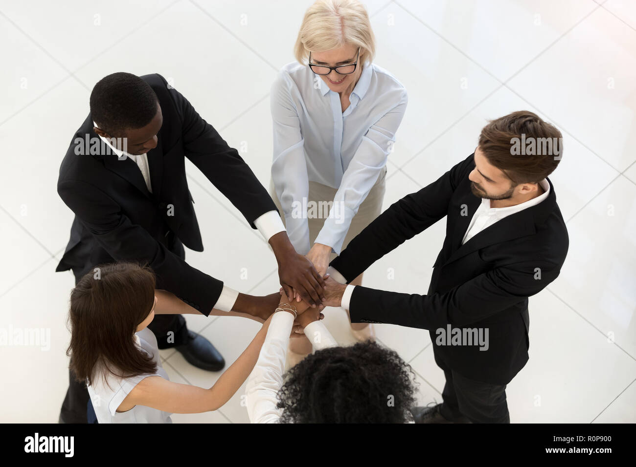 Top view of diverse employees stack hands showing unity Stock Photo - Alamy