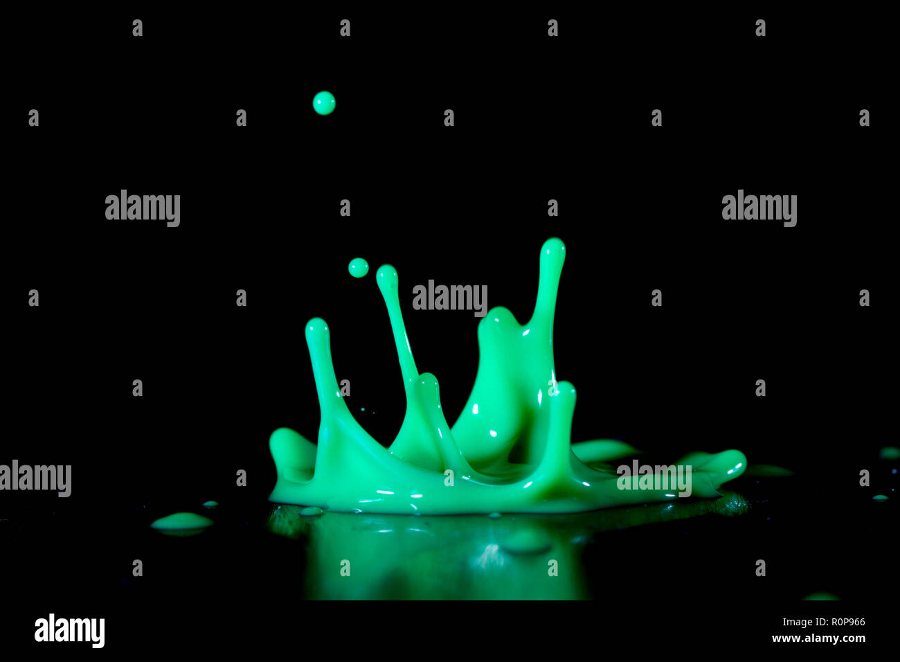Green paint, ink splash on black background Stock Photo - Alamy