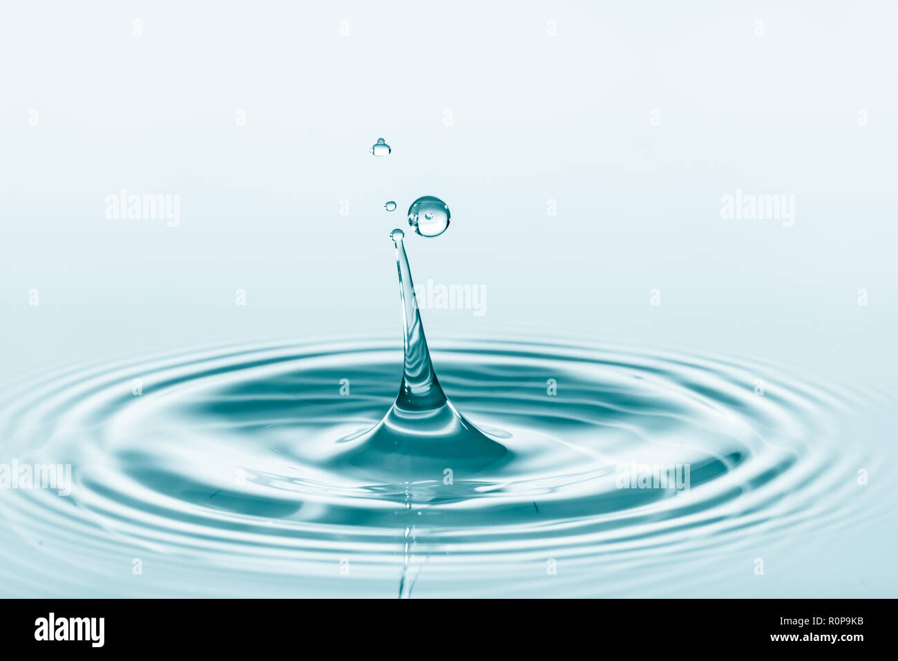 Water drop falling into water making a perfect droplet splash Stock ...