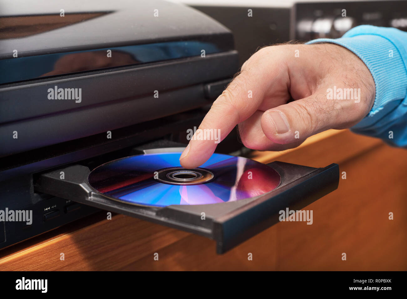 Hand holding DVD inserting to video player Stock Photo - Alamy