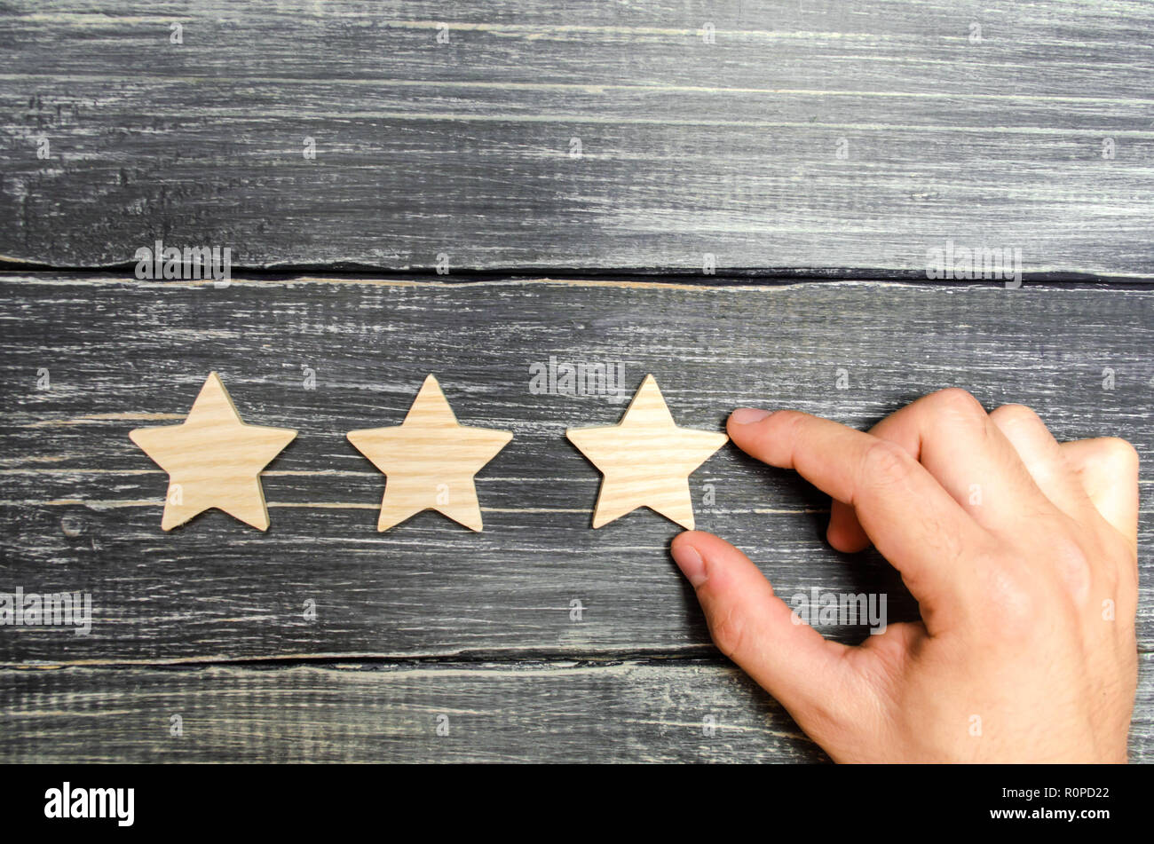 The hand puts the third star. concept of success and recognition ...