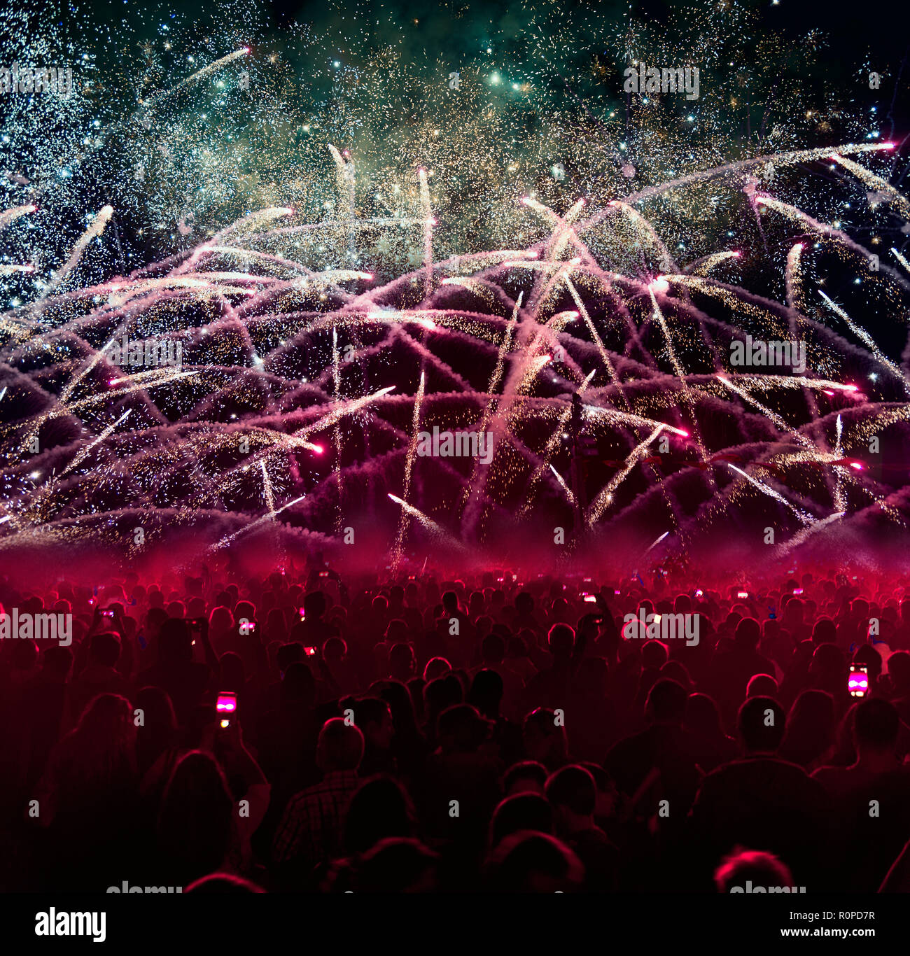 Crowded people with fireworks and red colored Stock Photo - Alamy