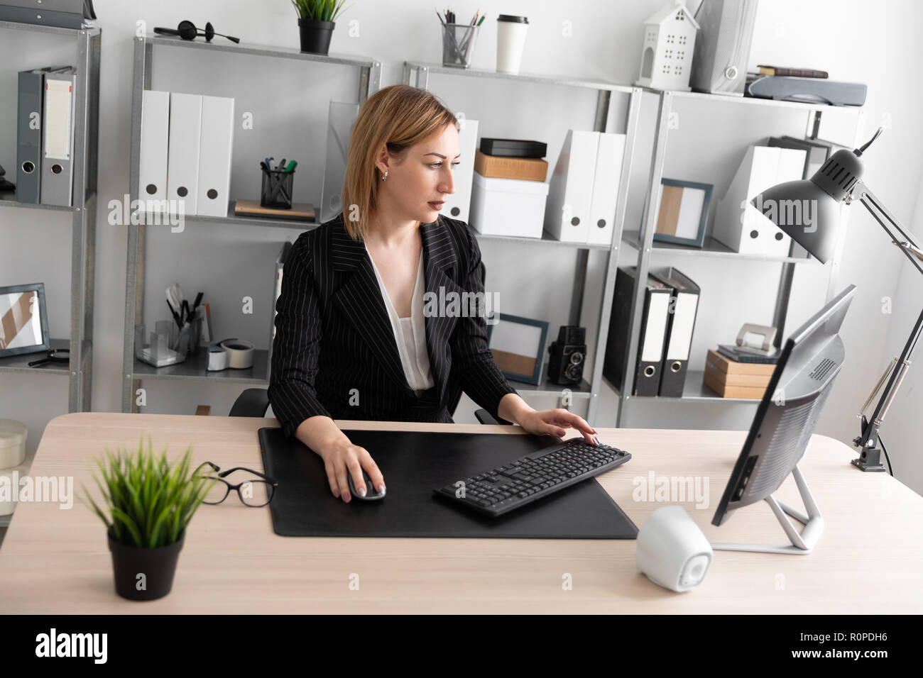A young girl working at a computer in the office Stock Photo - Alamy