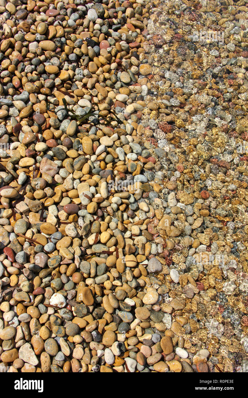 Pebbles texture with on half covered by sea water in sunny day Stock ...