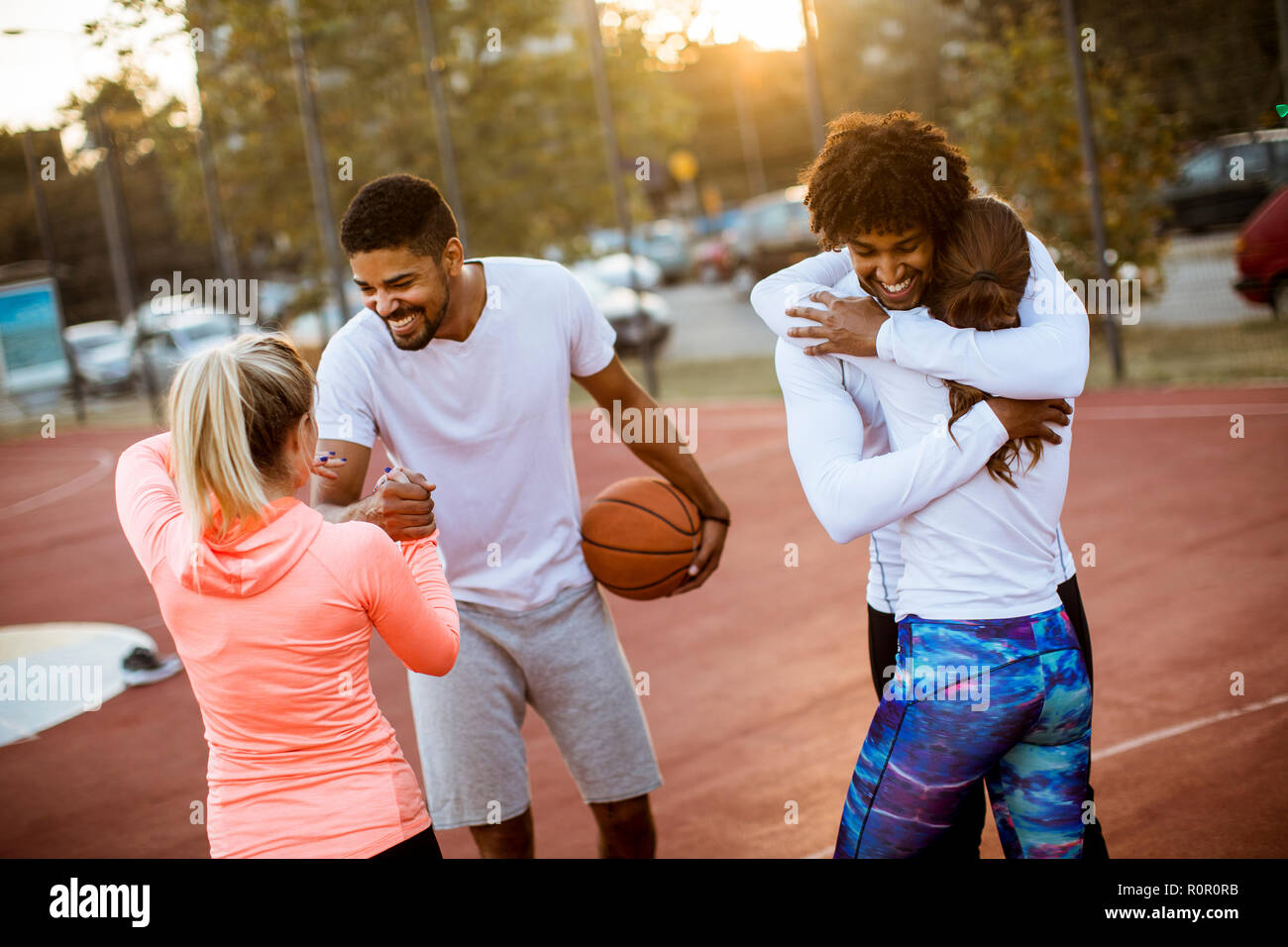 Group of multiethnic young people playing basketball on court Stock ...