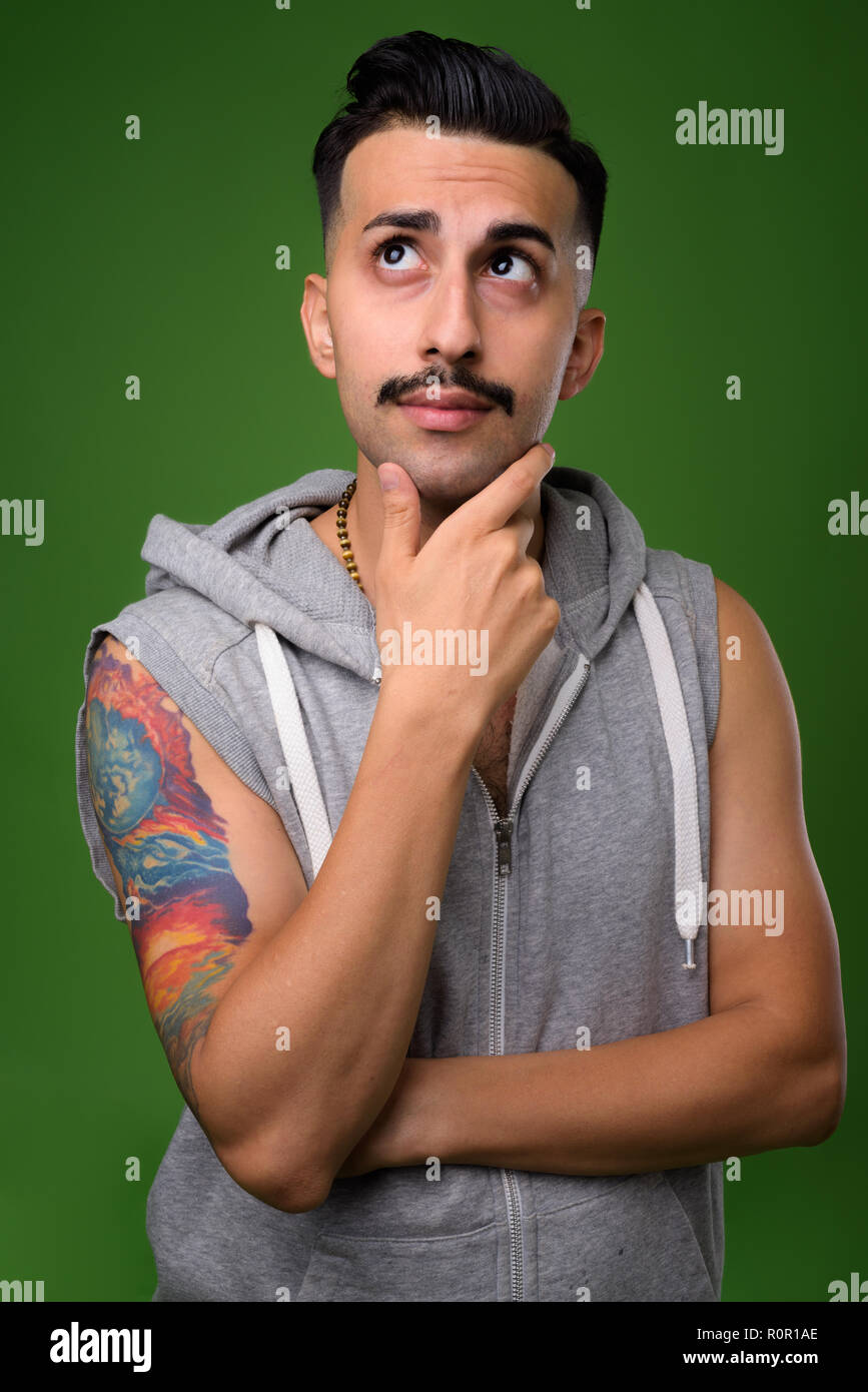 Young handsome Iranian man with mustache against green backgroun Stock ...