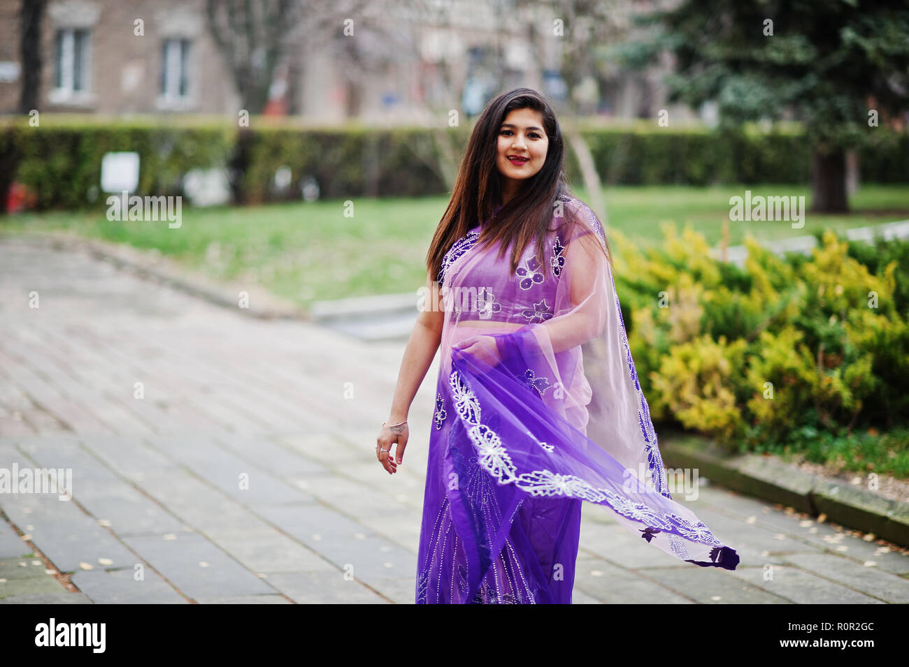 Indian hindu girl at traditional violet saree posed at autumn street ...