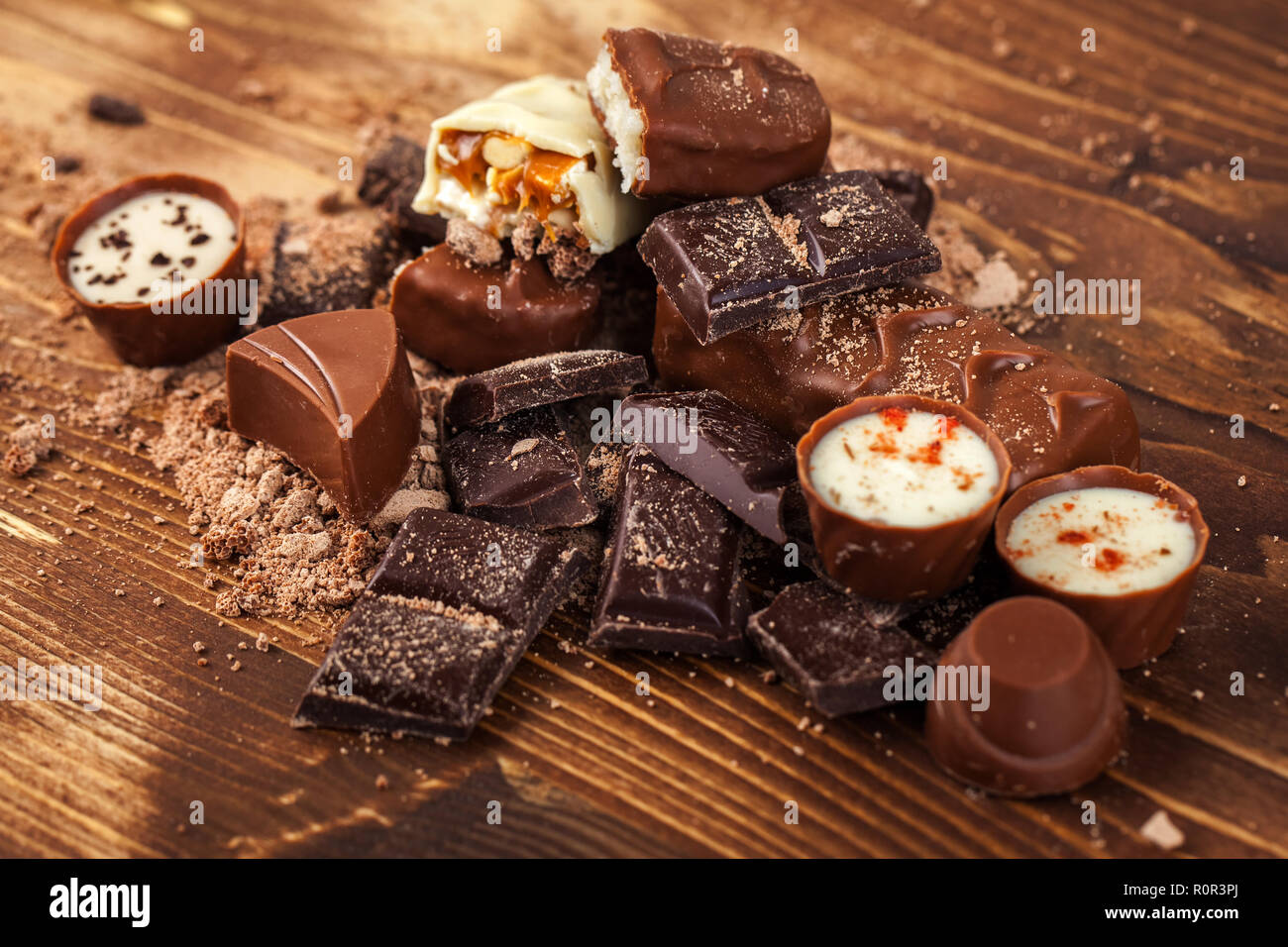 Various yummy chocolate candies on wooden table, sweets Stock Photo - Alamy