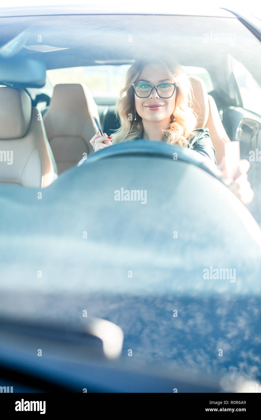 Image of happy blonde with glasses driving black car Stock Photo - Alamy