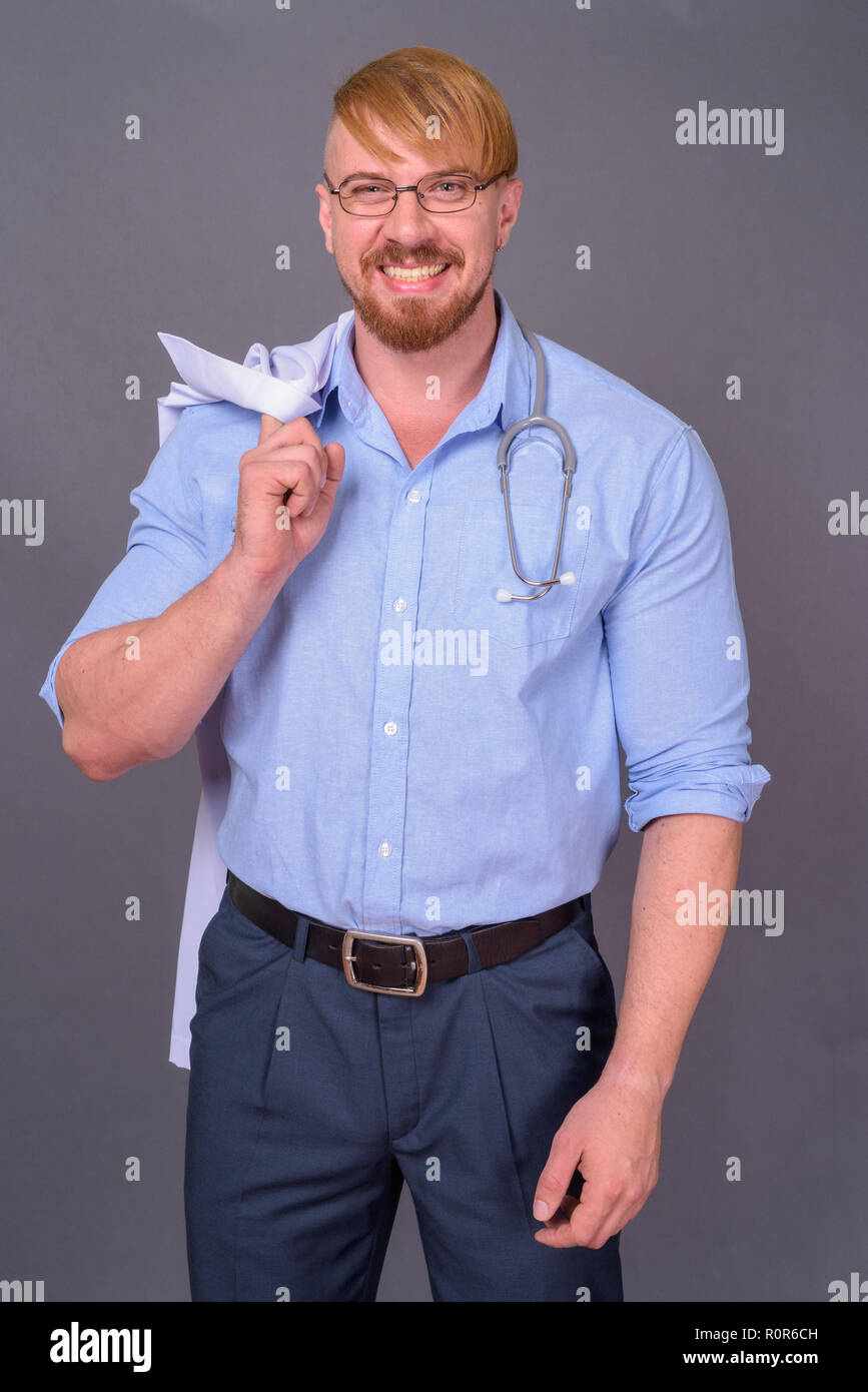 Bearded man doctor with blond hair against gray background Stock Photo ...
