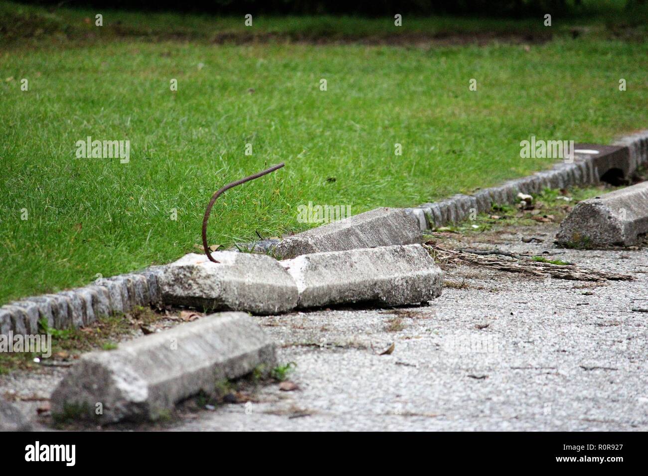 a road curb broken pieces with extended metal part Stock Photo - Alamy