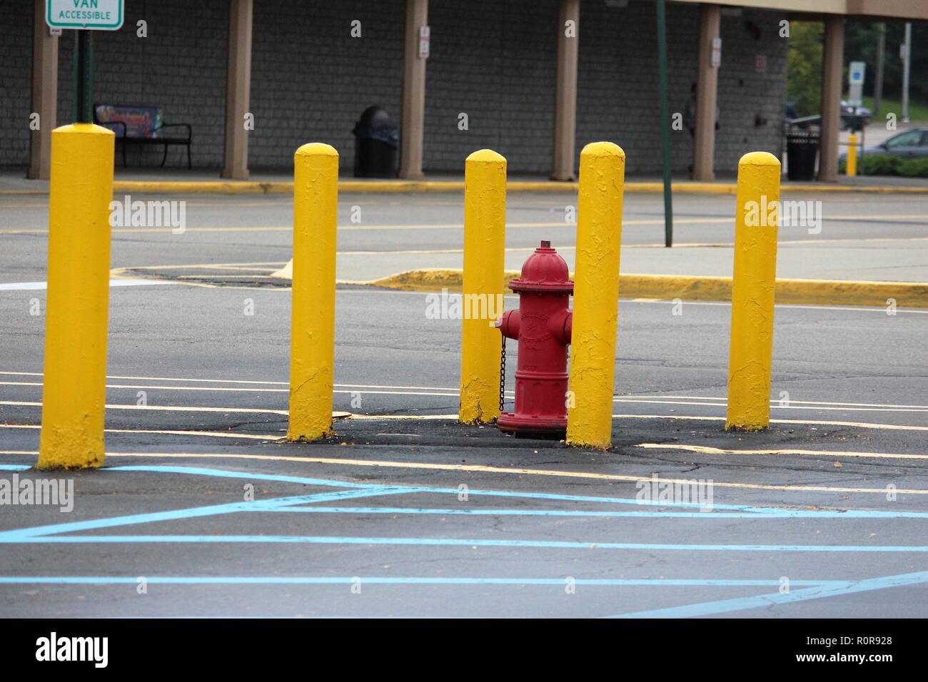 Fire hydrant surrounded by short yellow polls on a parking lot Stock ...
