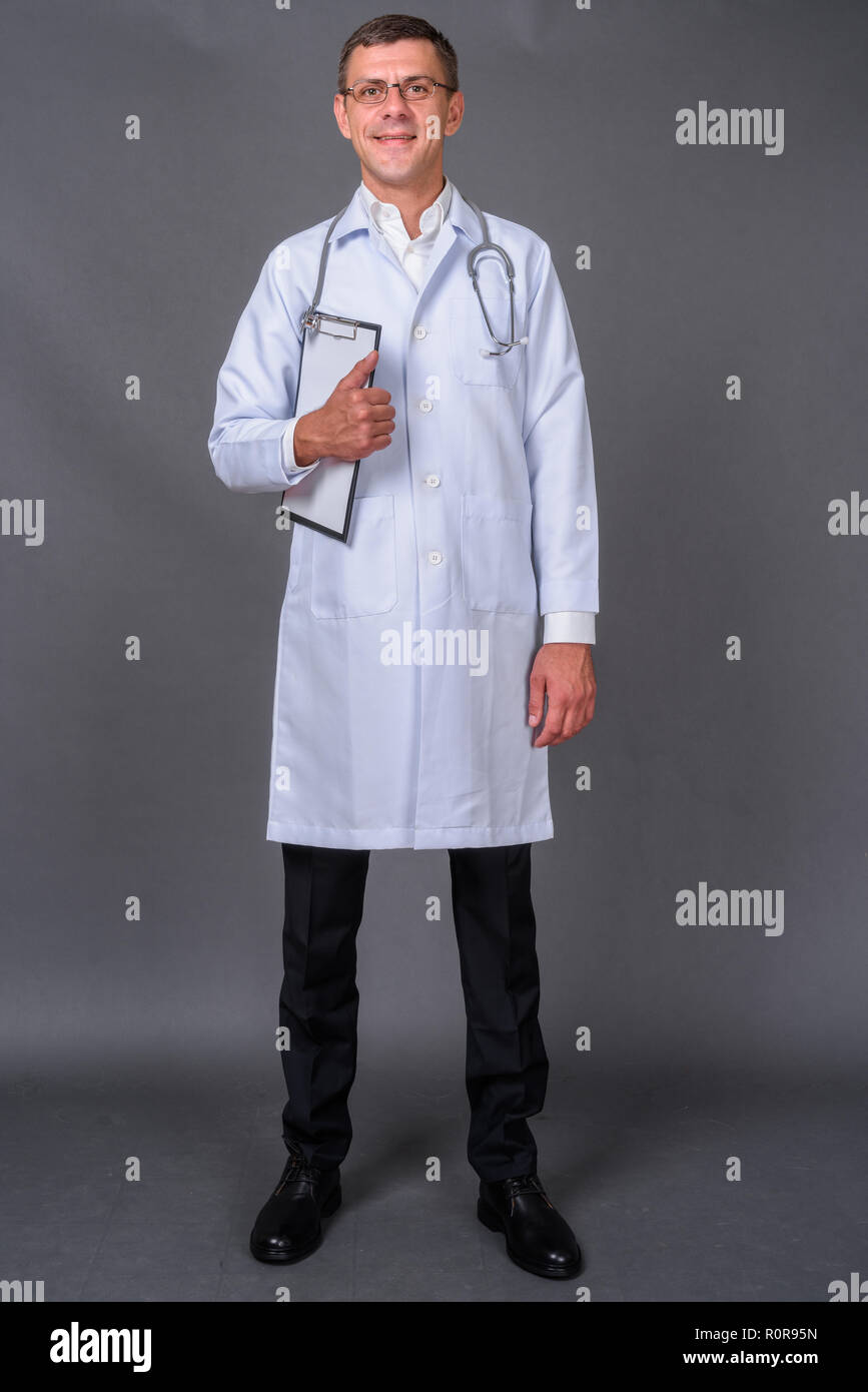 Handsome man doctor with short hair against gray background Stock Photo ...