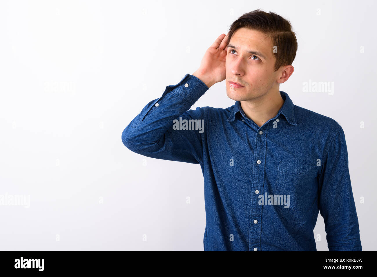 Studio shot of young handsome man listening while thinking again Stock ...